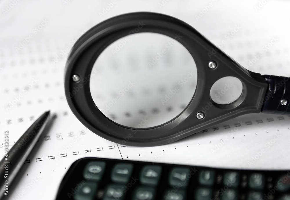 Magnifying glass over financial figures Stock Photo | Adobe Stock
