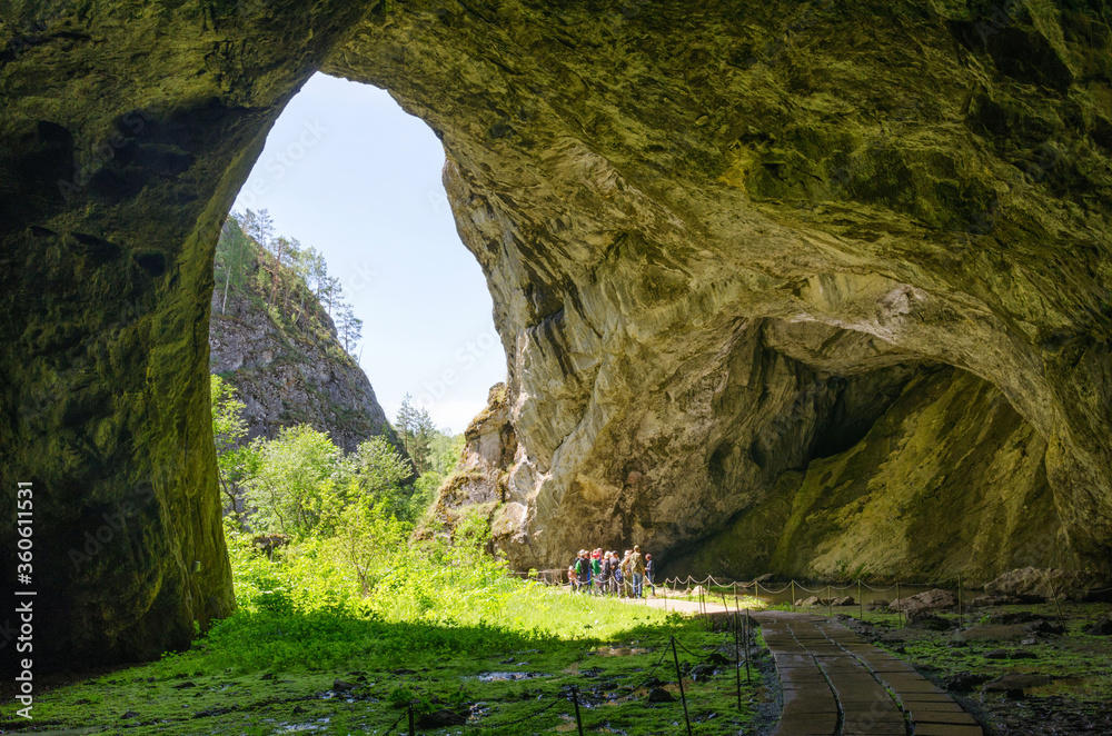 Entrance of Kapova Cave (Shulgan-Tash cave) with group of tourists in ...