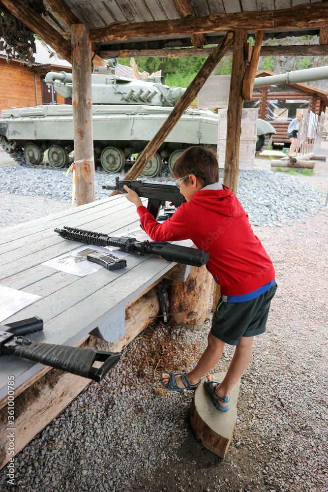 young boy with a machine gun in the outdoor shooting gallery Stock ...