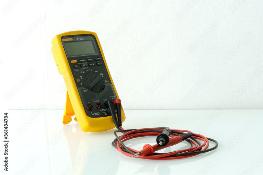 Yellow Digital multimeter with probes for measuring voltage, current ...