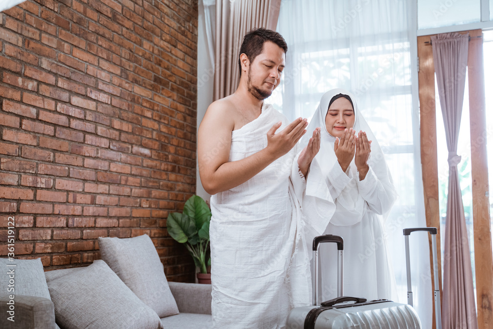 Muslim couple praying open their arm wearing ihram Stock Photo | Adobe ...