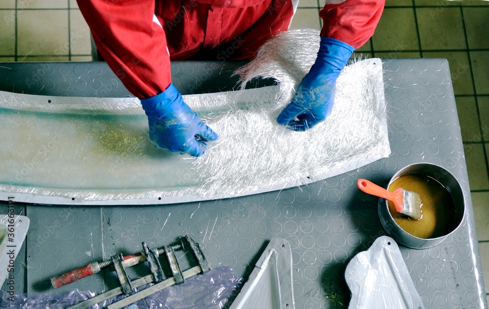 Installation of fiberglass: worker manually realizes a component in ...