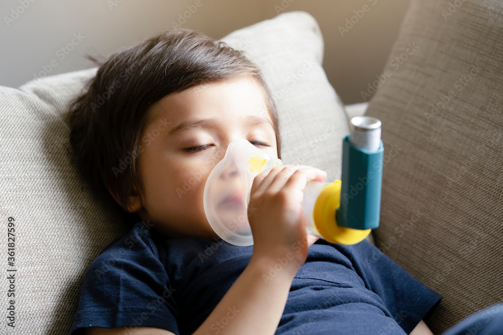 Poor boy tired from chest coughing holding inhaler mask while sleeping ...