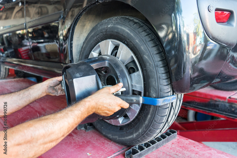 Tyre / tire fitting, rod adjustment. A mechanic man on the a vehicle ...