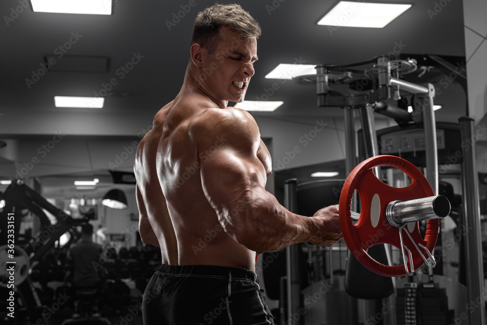 Muscular man working out in gym doing exercise for biceps. Strong male naked torso Stock Photo ...