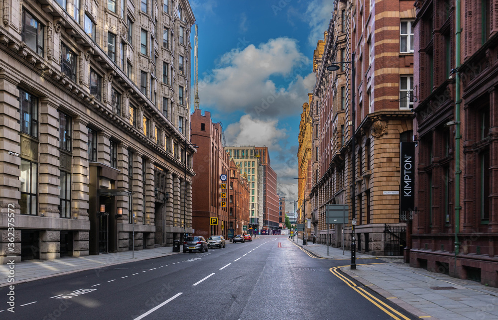 An empty streetscene of Whitworth Street under a vibrant blue sky. One ...