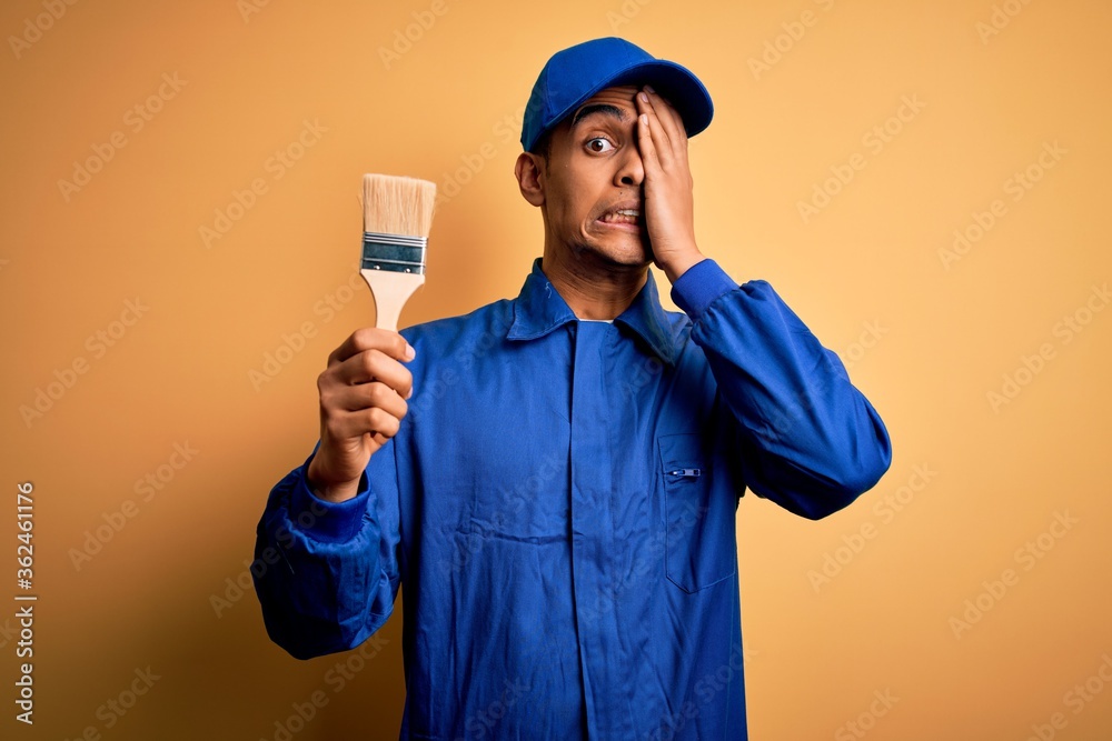 Young handsome african american painter man wearing uniform using ...