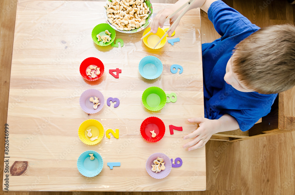 Little child doing simple math exercises. Early education, counting ...
