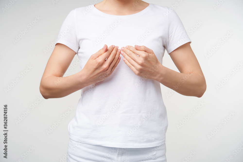 Studio photo of young female dressed in white t-shirt learning sign ...