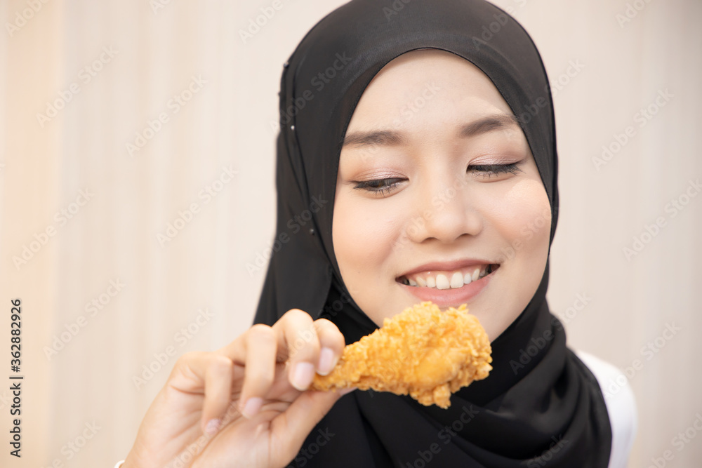 Photo Stock hungry islamic woman looking, eating halal fried chicken ...