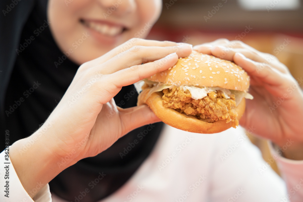 hungry islamic woman looking, eating halal fried chicken burger ...