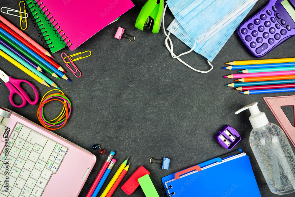 School supplies and COVID 19 prevention items. Top view frame on a ...