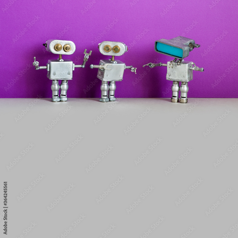 Simplified design robotic toys. Three metal silver robots on purple ...