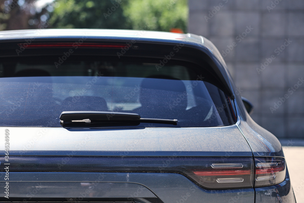 Back window of black car parked on the street in summer sunny day, rear ...