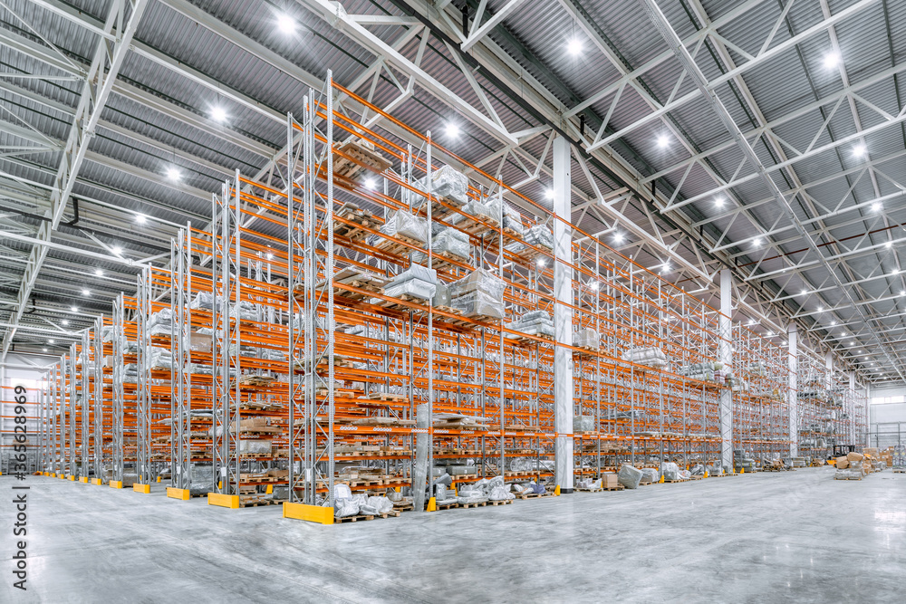 Large industrial warehouse. Tall racks are completely filled with boxes ...
