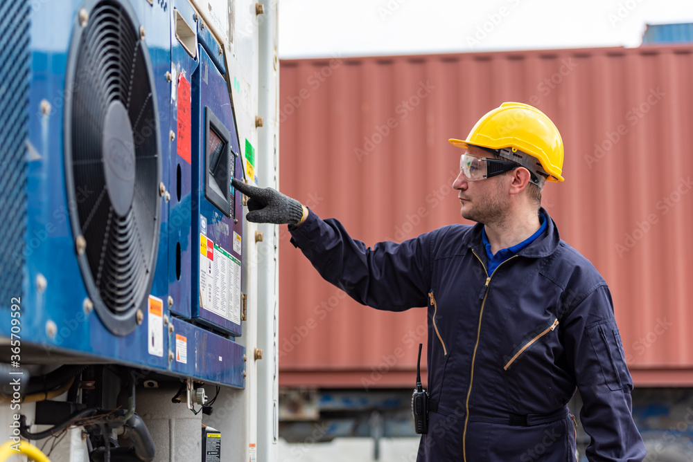 Engineer checking and setting temperature cooling units in freight of ...