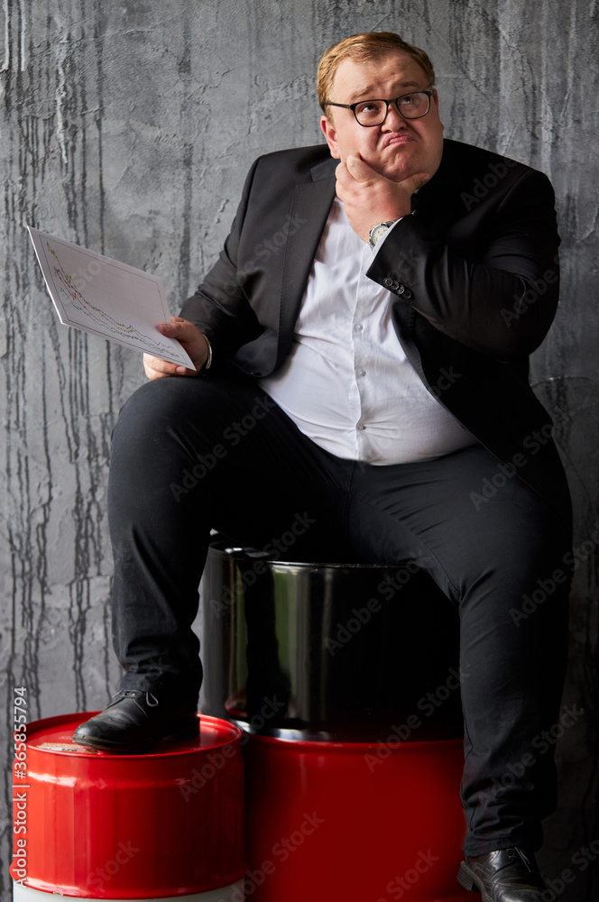 fat caucasian businessman looks at paper with current situatuin showing ...