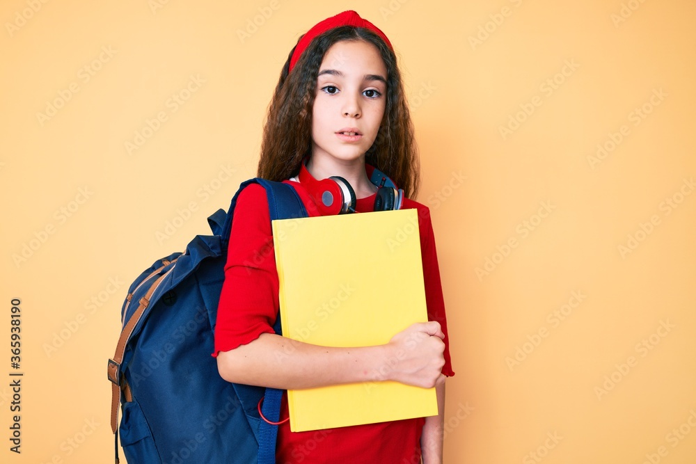 Foto de Stock Cute hispanic child girl wearing student backpack and ...