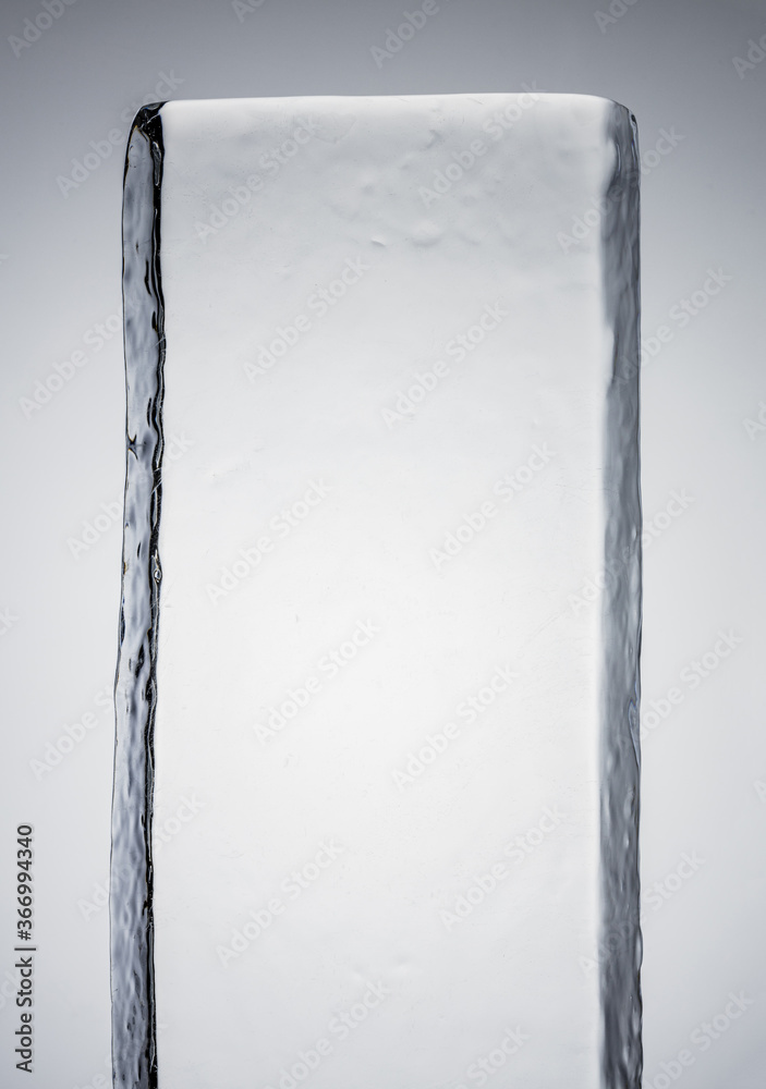Large rectangle of crystal clean ice against light grey background ...