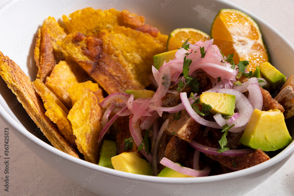 Ceviche de chicharron con cebolla platano limon y cerdo, en un plato ...