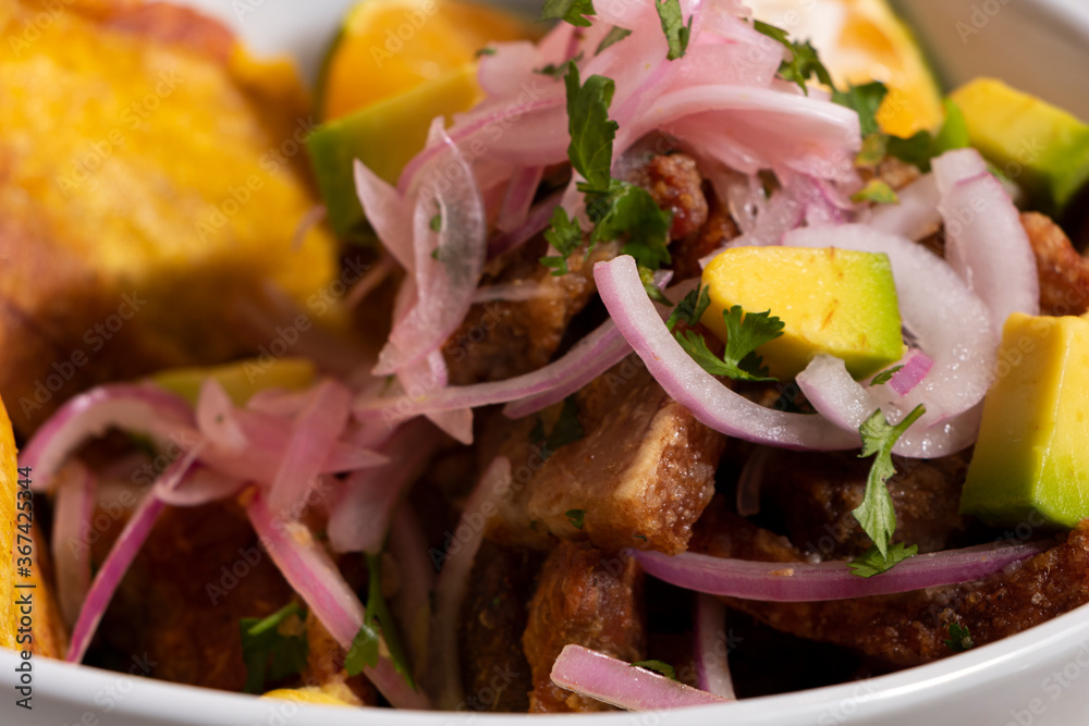 Ceviche de chicharron con cebolla platano limon y cerdo, en un plato ...