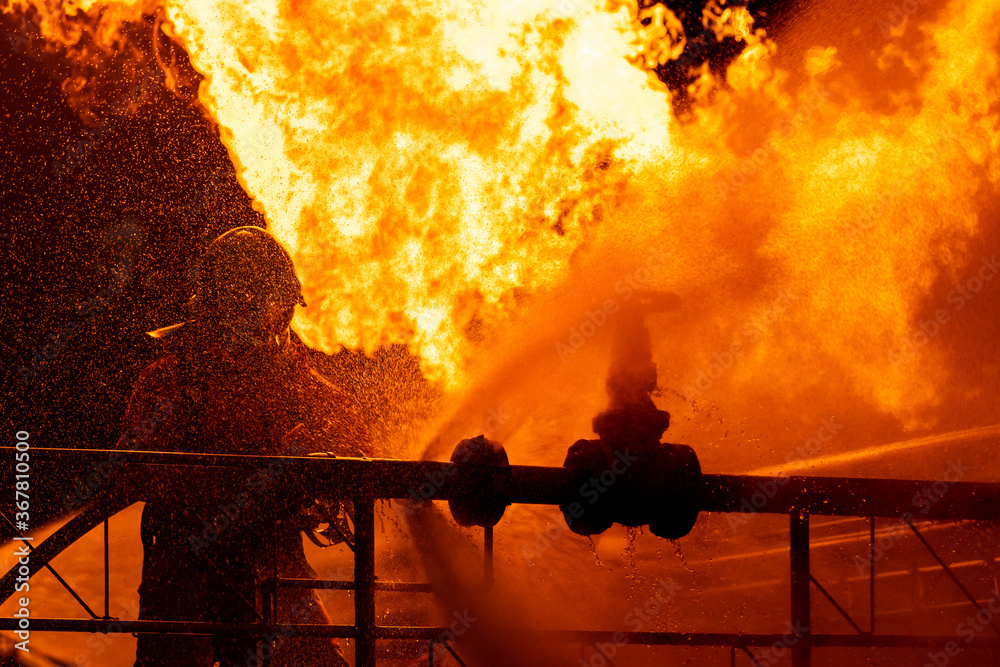 Firefighters using water fog spraying down fire from oil rig factory ...