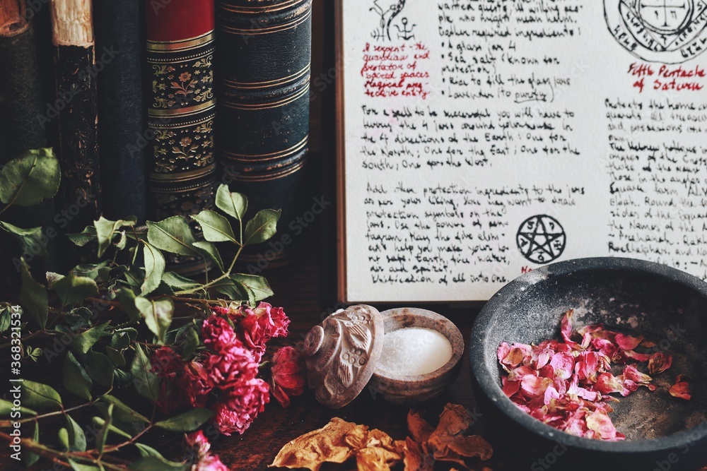 Wiccan witch altar with an open book of shadows with hand written spell ...