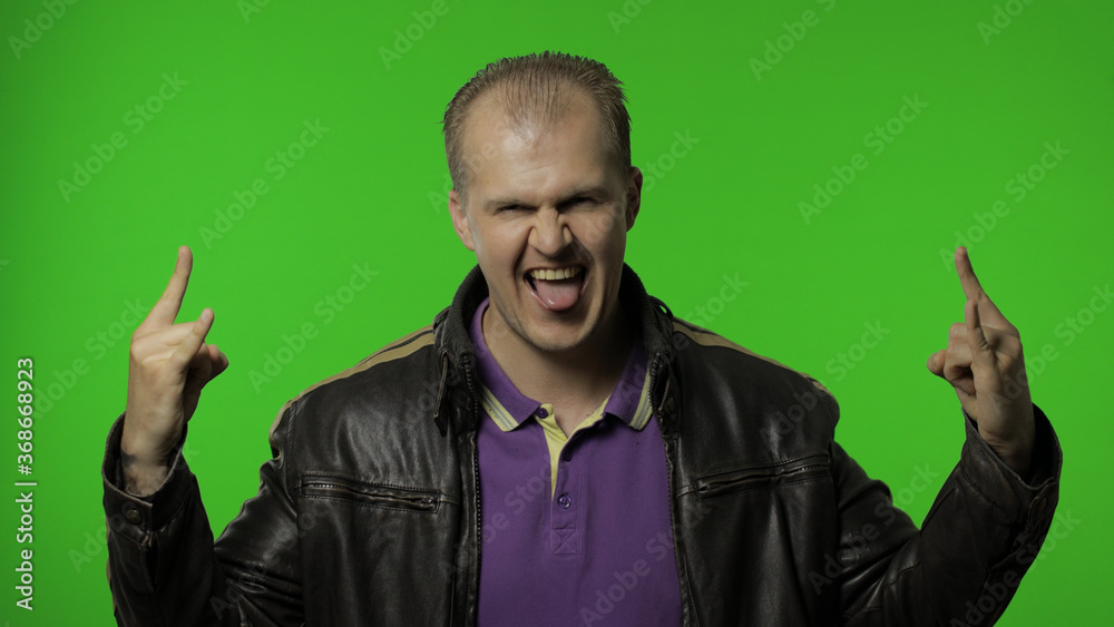 Rocker man showing rock and roll sign, devil horns gesture, looking ...