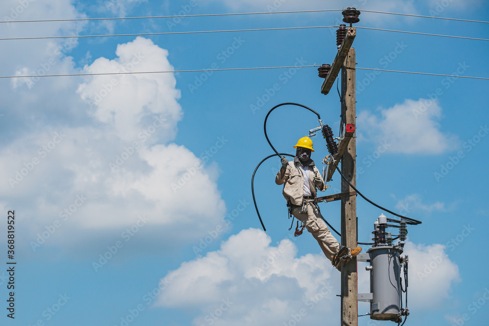 Stock-Foto „Lineman climb concrete pole are installing hotline-clamps ...