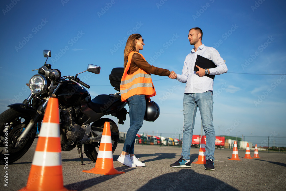 Foto Motorcycle driving school. Instructor and student handshake before ...