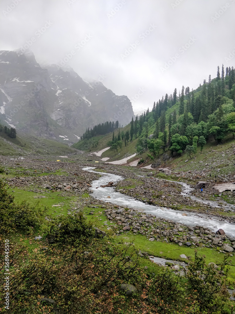 Snow patches and river stream flowing through rocks in an epic Indian ...