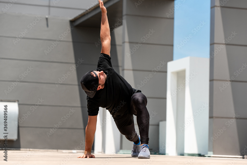Fit sports man warming up with spider lunge exercise outdoors on ...