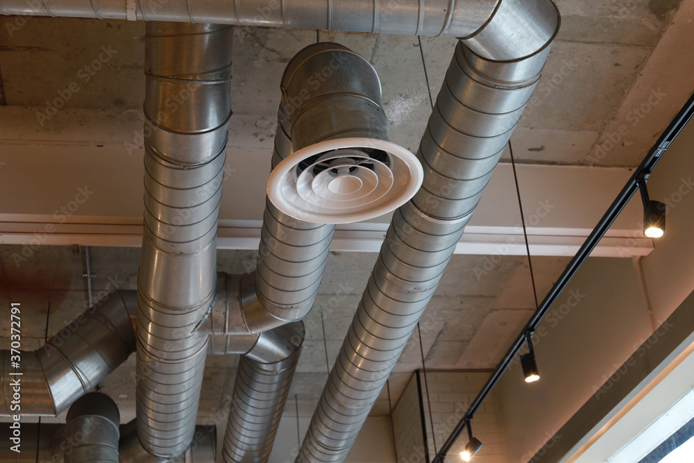 Ventilation pipes in silver insulation material hanging from the ...