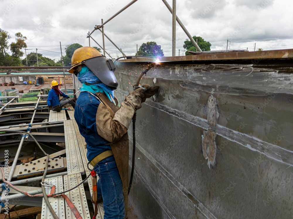 The welder is welding a steel structure work with process Flux Cored ...