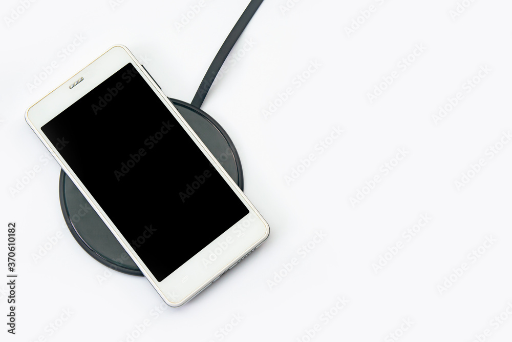 Smartphone charging on a wireless charger on white background. black ...