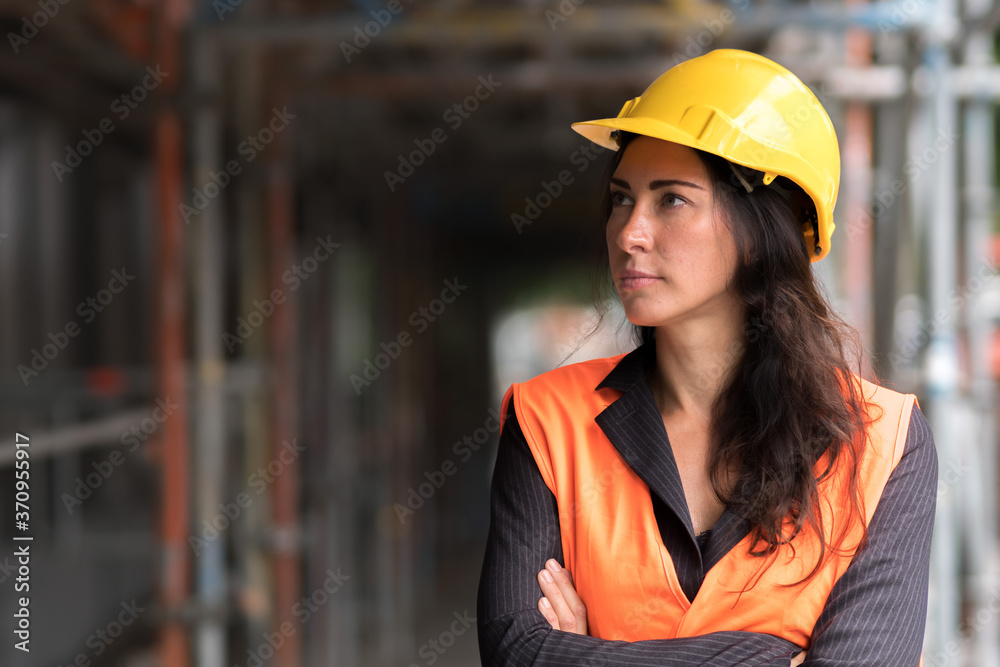 Portrait of a beautiful female factory worker wearing a protective ...