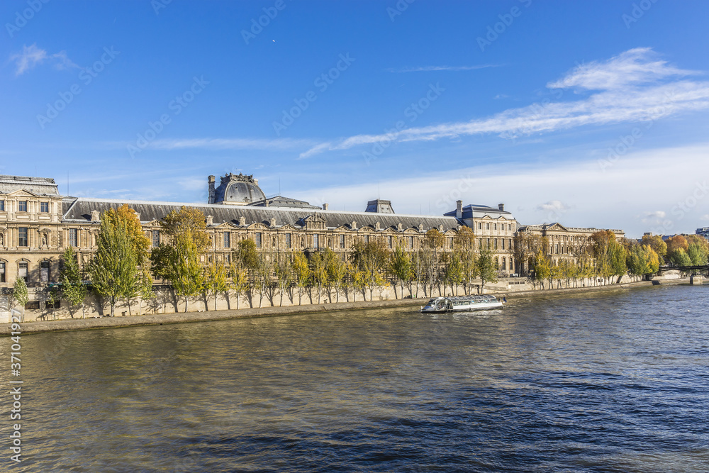 View of famous Louvre Museum from the Seine river. Louvre Museum is one ...