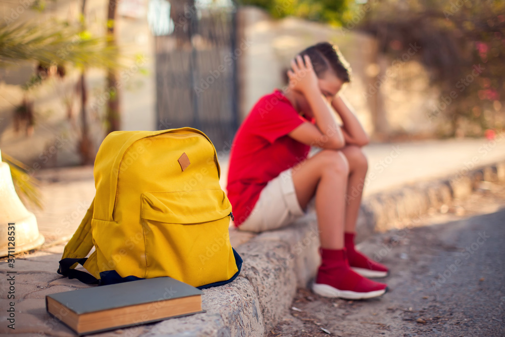Sad pupil feeling strees sitting outdoor. Boy feeling stress. Children ...