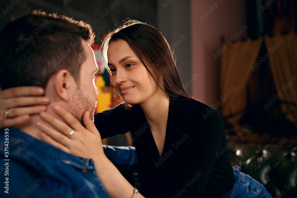 girl hugs her boyfriend sitting on the couch, home interior, young ...