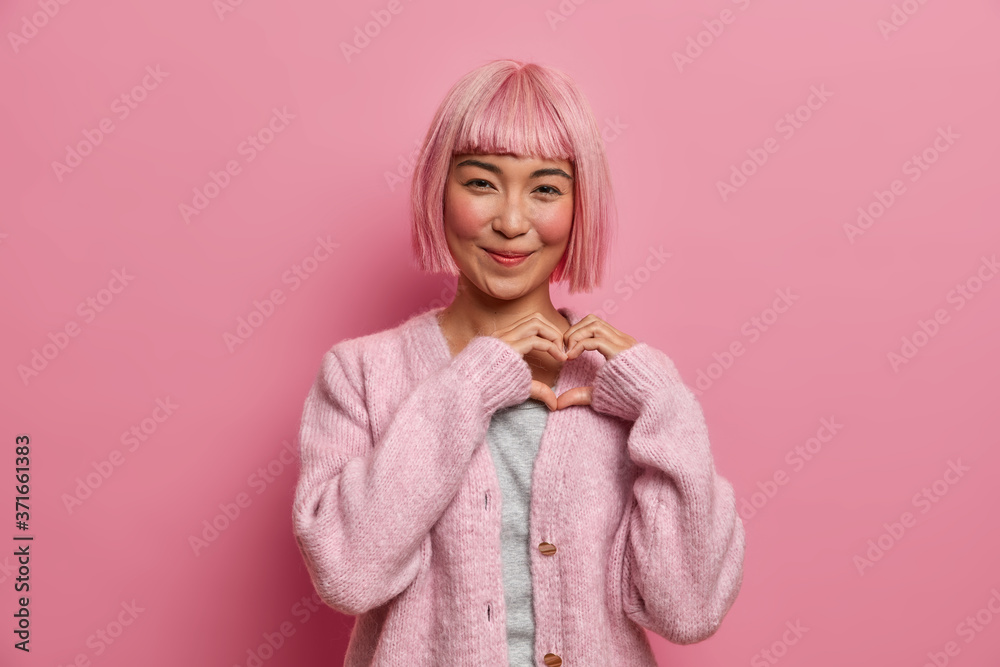 Kind positive amiable Asian woman with bob hairstyle, makes heart shape ...