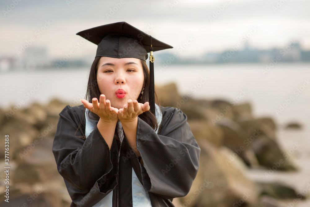 Happy and excited portrait of young Asian student girl with graduation ...