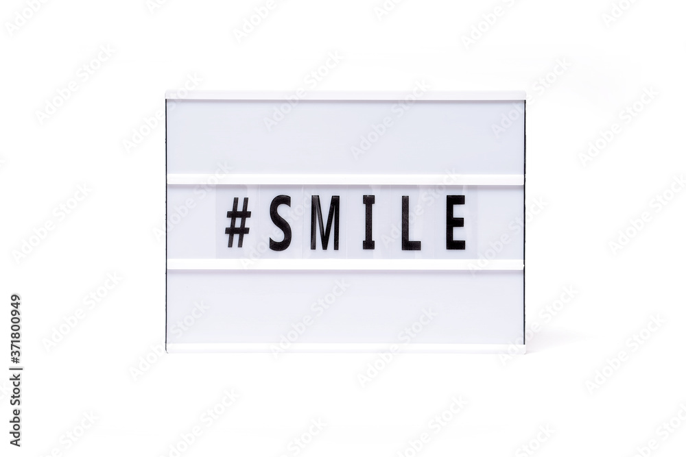 Smile. Text on a vintage lightbox display placed on a white table on a ...