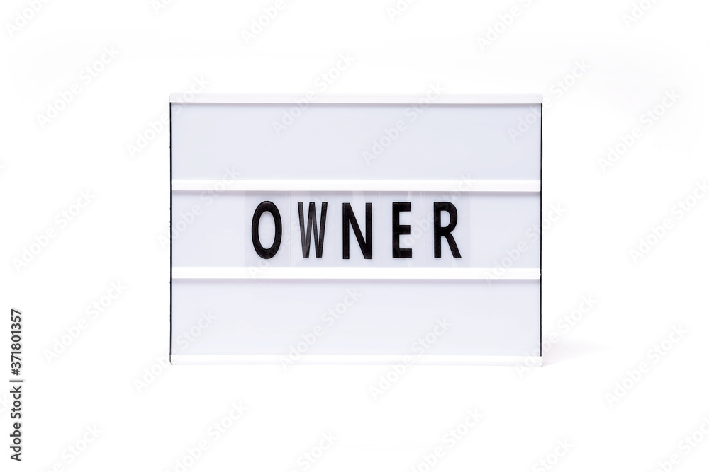 Owner. Text on a vintage lightbox display placed on a white table on a ...