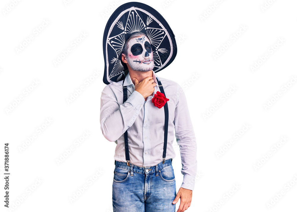 Man wearing day of the dead costume over background touching painful ...