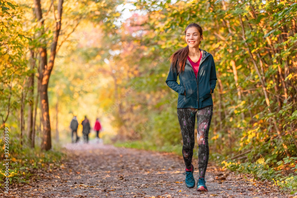 Woman walking in autumn forest nature path walk on trail woods ...