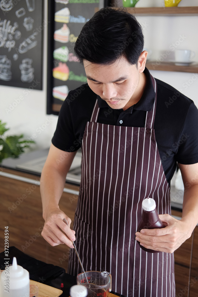 Smiling Asian barista young man pouring fresh Chocolate art in a ...