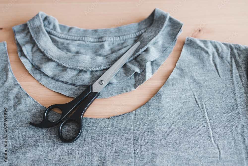 upcycling old clothes concept, t-shirt with scissors to cut a new ...