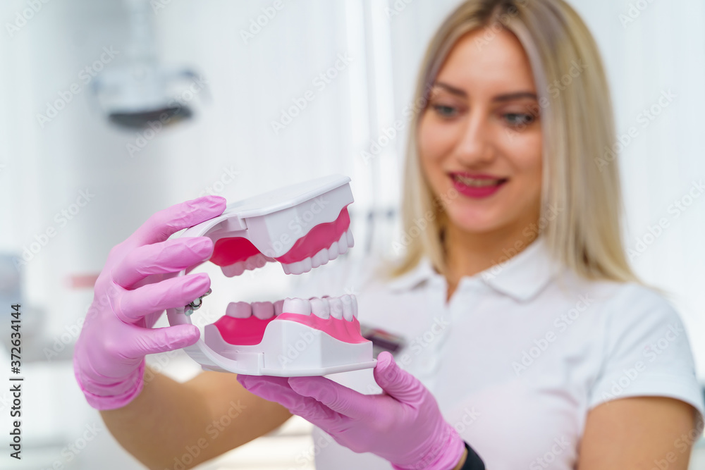 Doctor shows on a plastic jaw sample or model different methods of ...