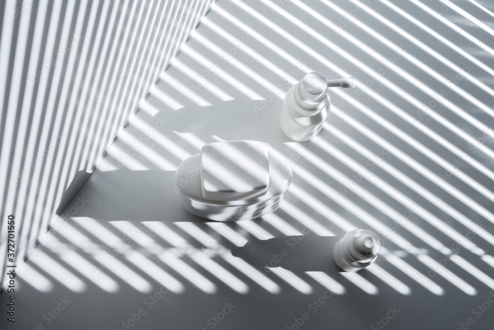 Still life with three white vials and diagonal striped shadow Stock ...