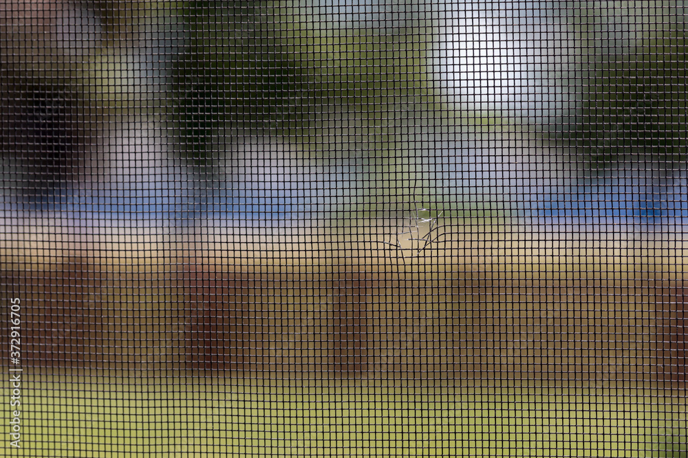 Closeup of old window screen mesh with hole. Concept of DIY home repair ...
